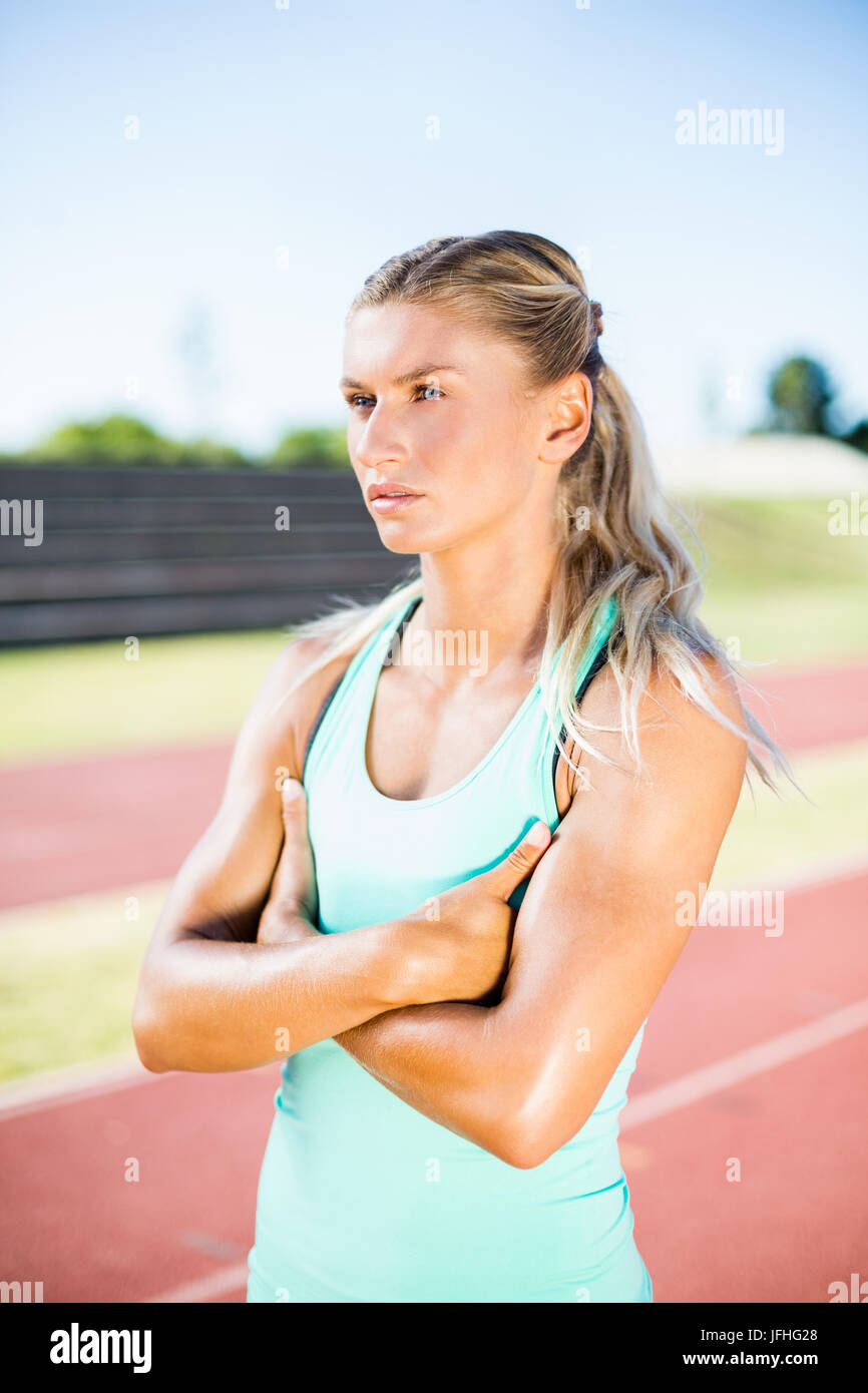 Female athlete standing with arms crossed on the running track Stock ...