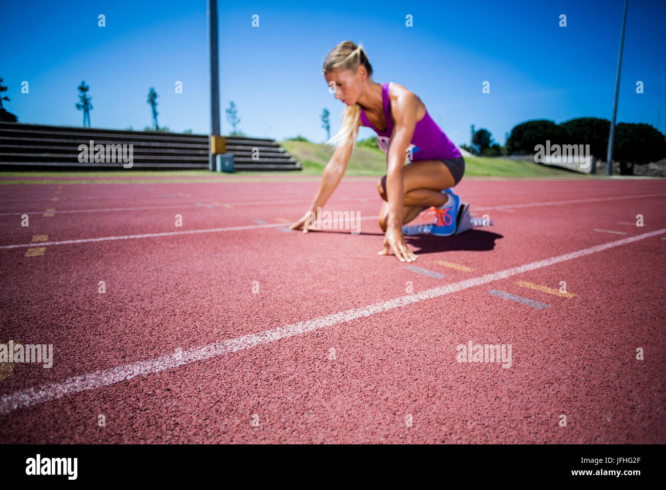 Female athlete ready to run on running track Stock Photo - Alamy
