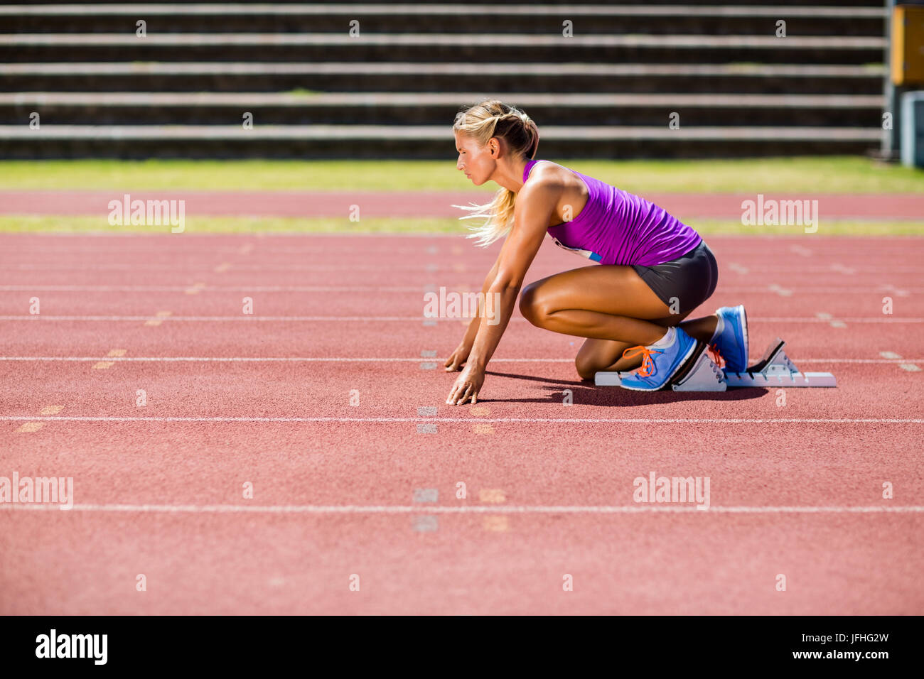 Female athlete ready to run on running track Stock Photo - Alamy
