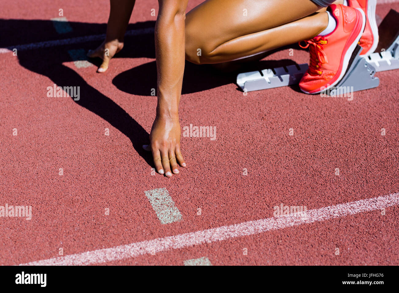 Female athlete ready to run on running track Stock Photo - Alamy