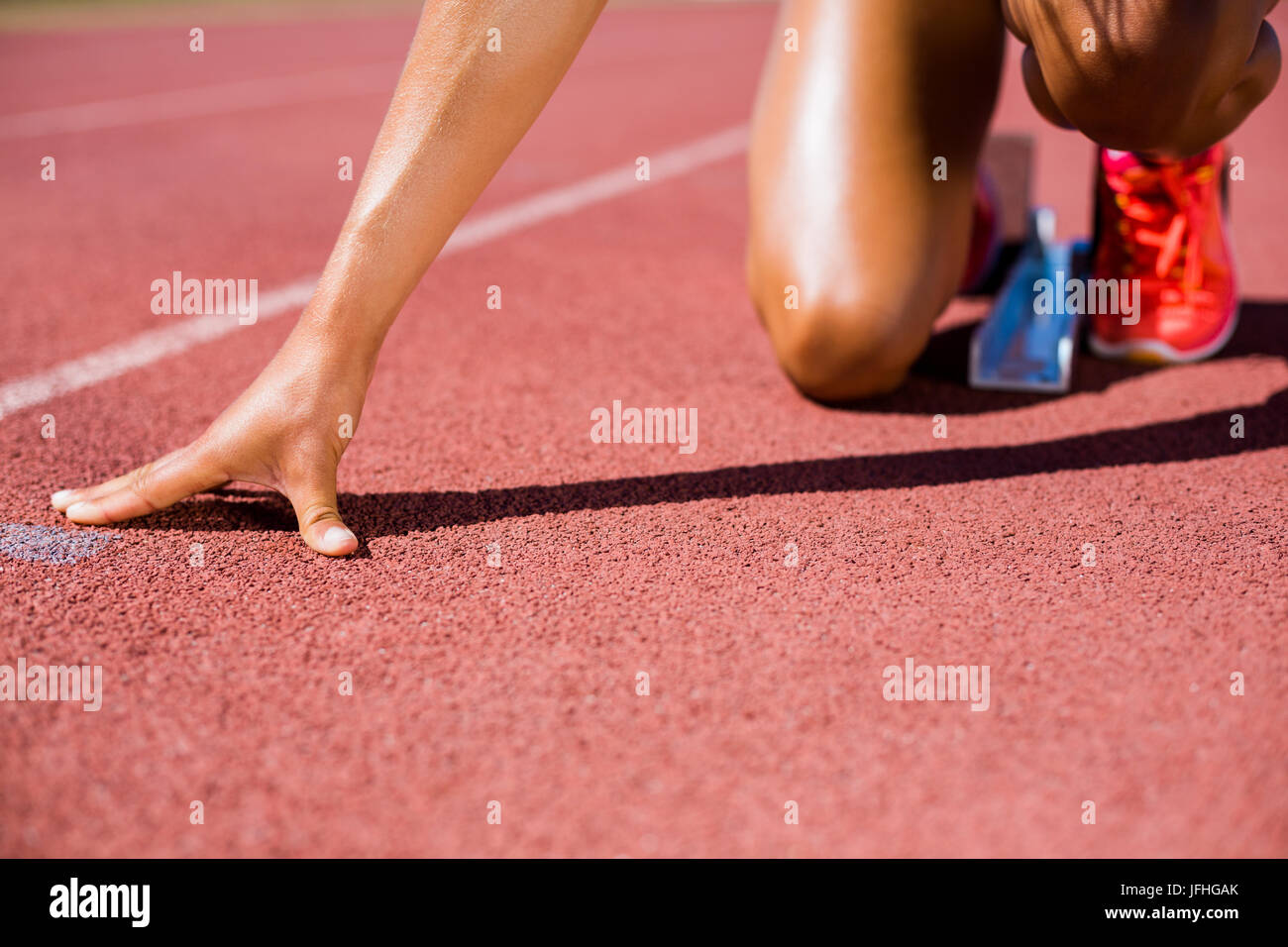 Female athlete ready to run on running track Stock Photo - Alamy