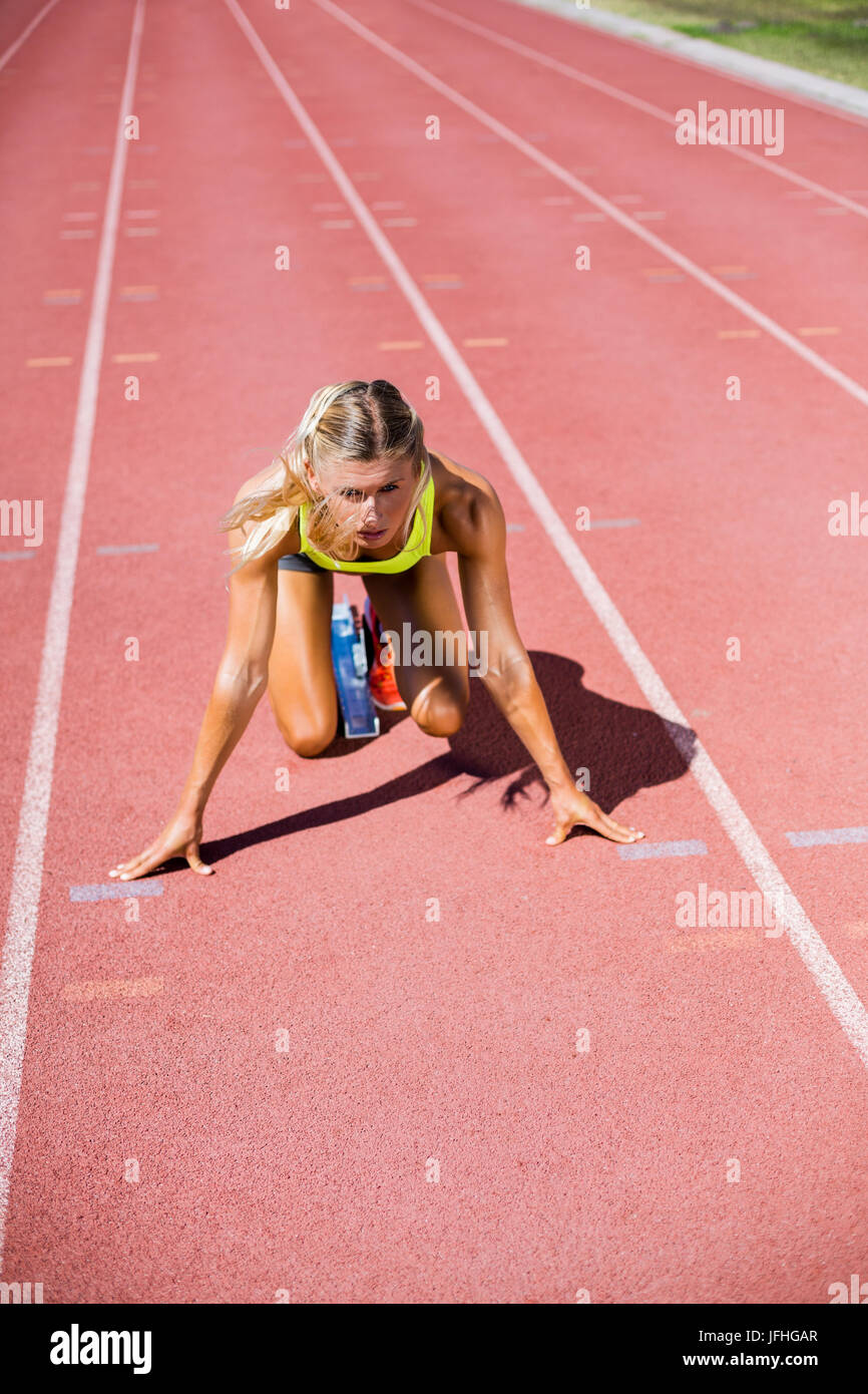Female athlete ready to run on running track Stock Photo - Alamy