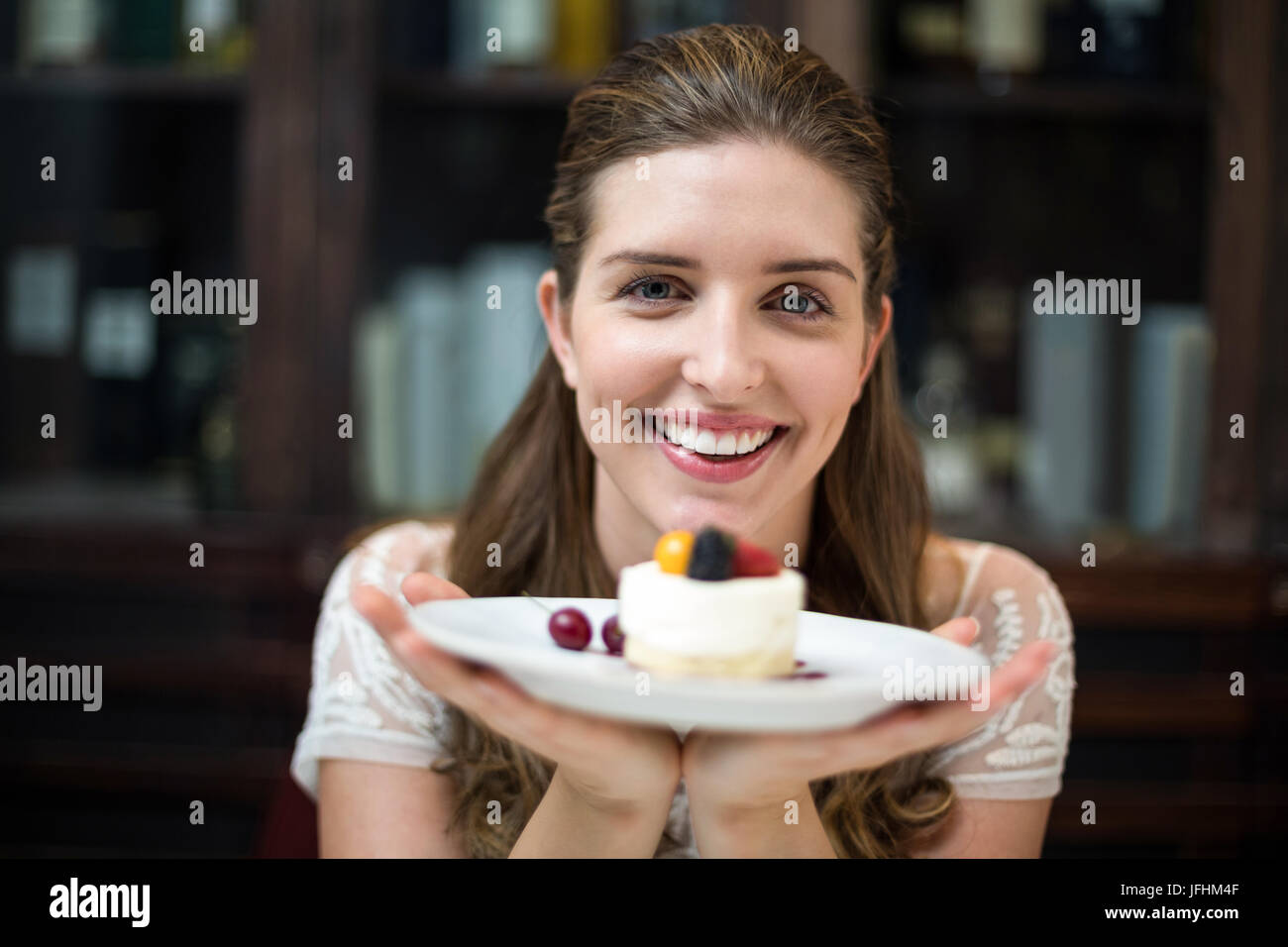Happy woman at restaurant holding desert in plate Stock Photo - Alamy