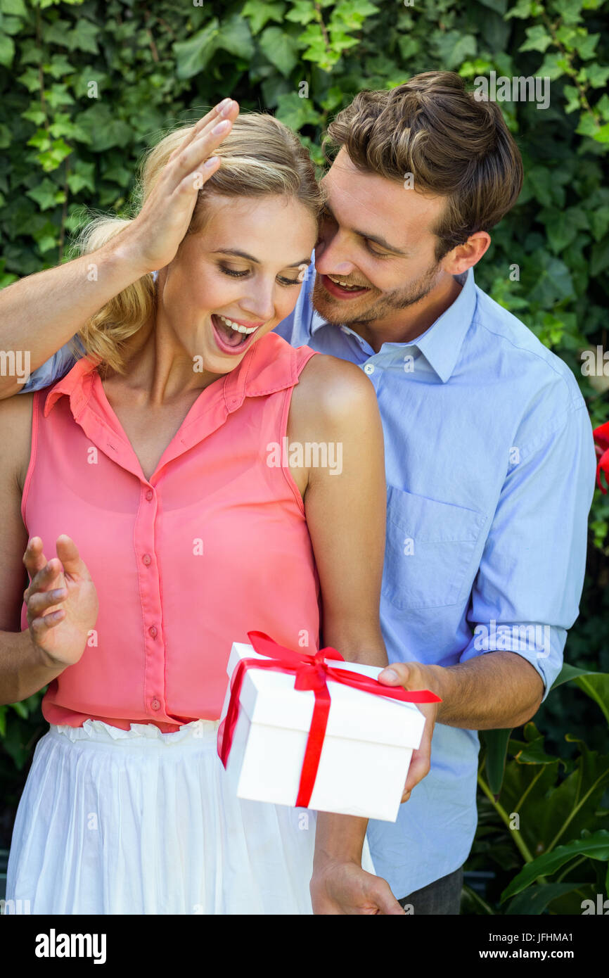 Romantic man giving gift to woman at front yard Stock Photo - Alamy