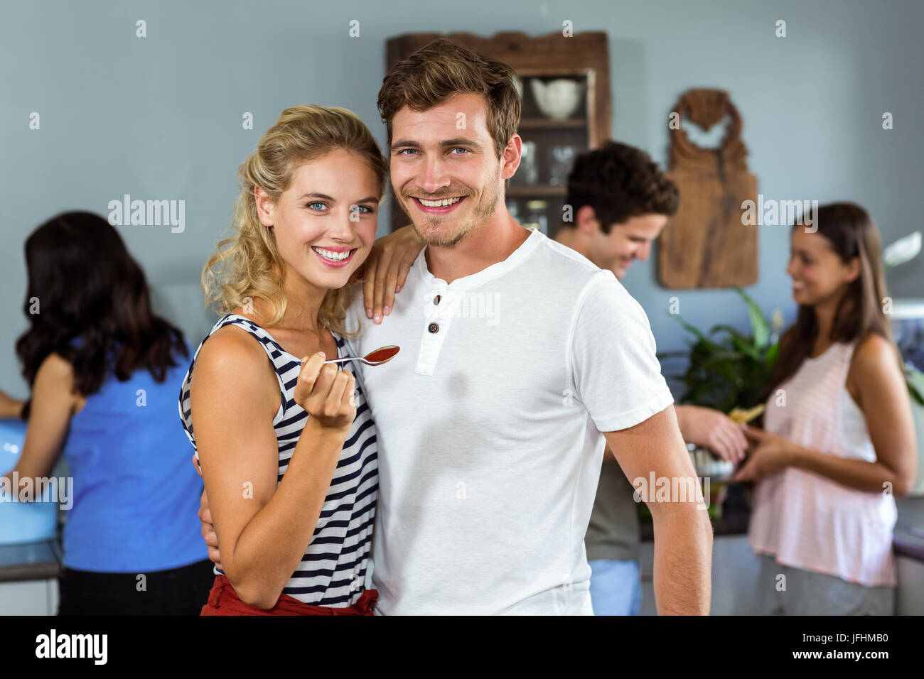 Young couple with friend in background at home Stock Photo - Alamy