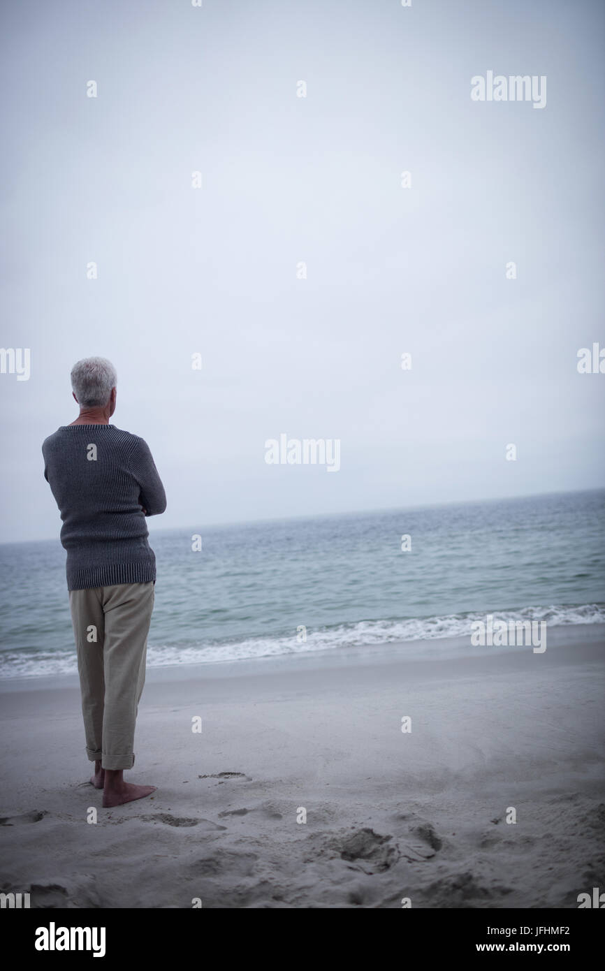 Rear view of senior man standing on the beach Stock Photo - Alamy