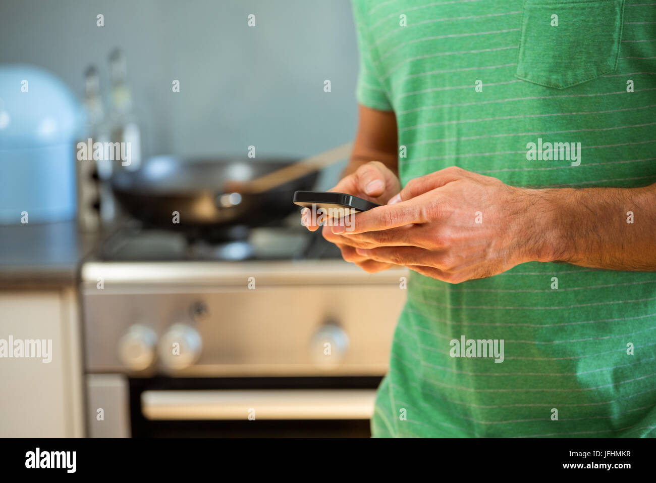 Mid adult man using mobile phone kitchen hi-res stock photography and ...