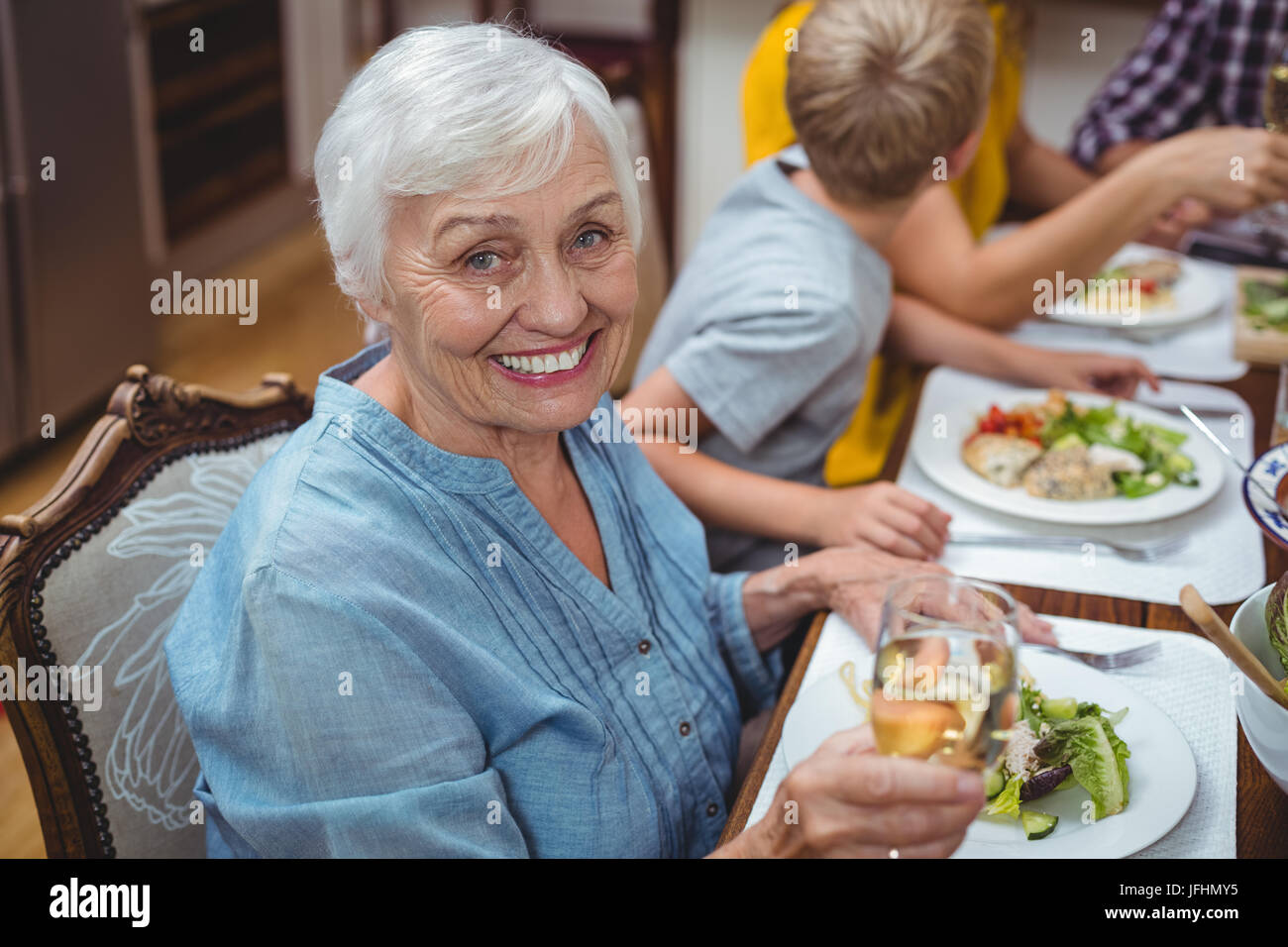 Portrait of smiling granny sitting at dining table Stock Photo - Alamy