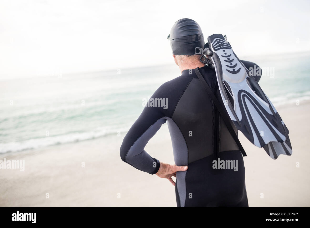 Rear view of senior man with flipper standing on beach Stock Photo - Alamy