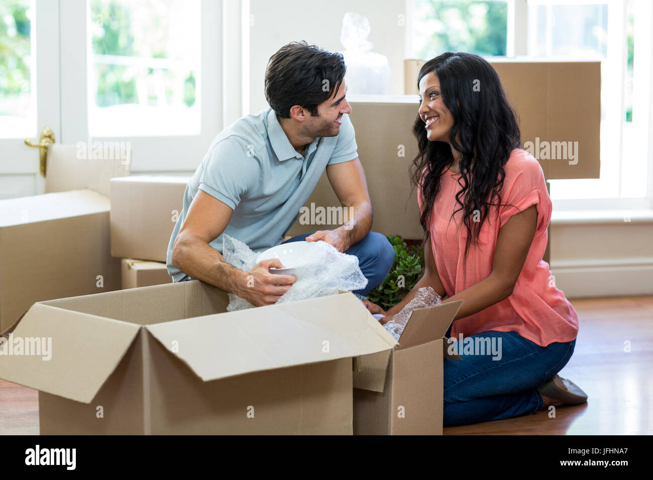 Young couple unpacking carton boxes in their new house Stock Photo - Alamy