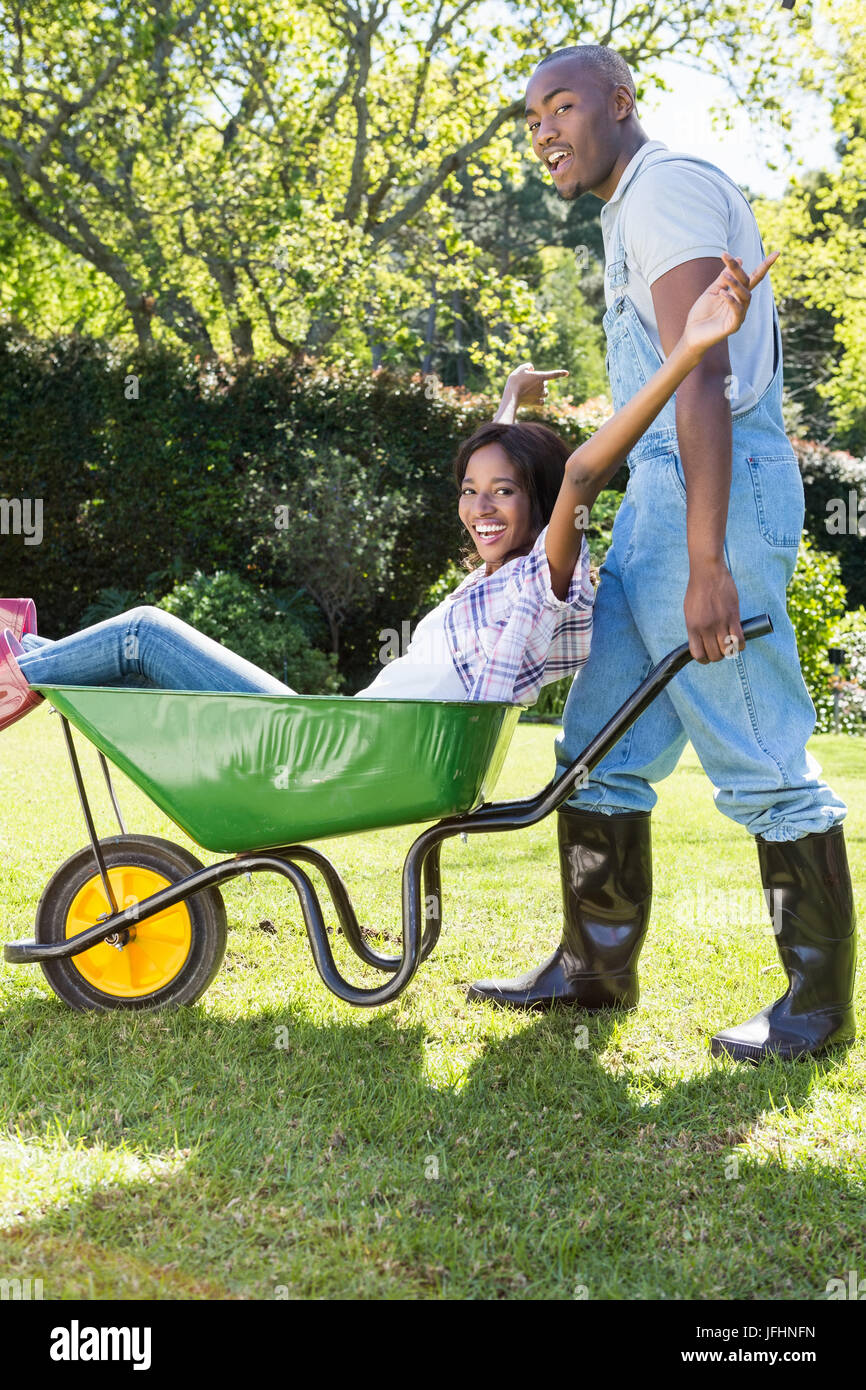 Young man giving woman a ride in the wheelbarrow Stock Photo - Alamy