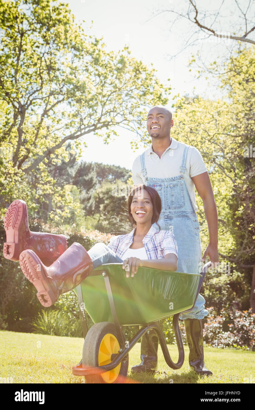 Young man giving woman a ride in the wheelbarrow Stock Photo - Alamy