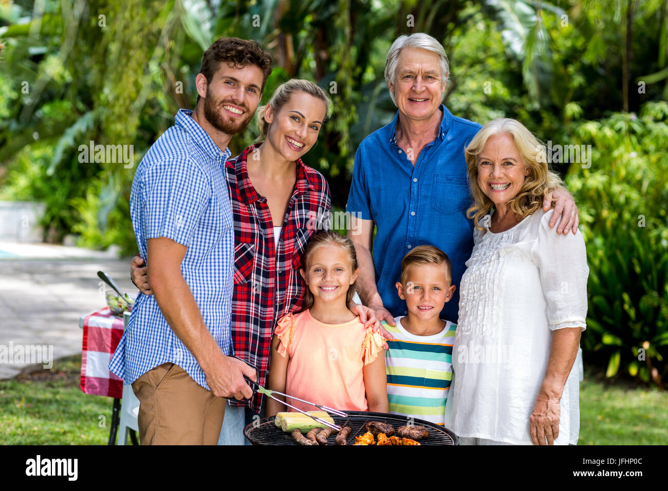 Happy family grilling food in barbeque at yard Stock Photo - Alamy