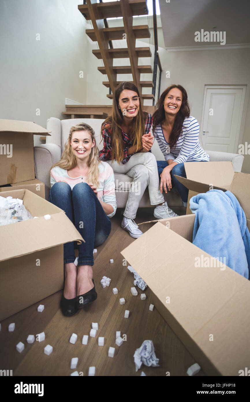 Portrait of friends sitting in their new house Stock Photo - Alamy