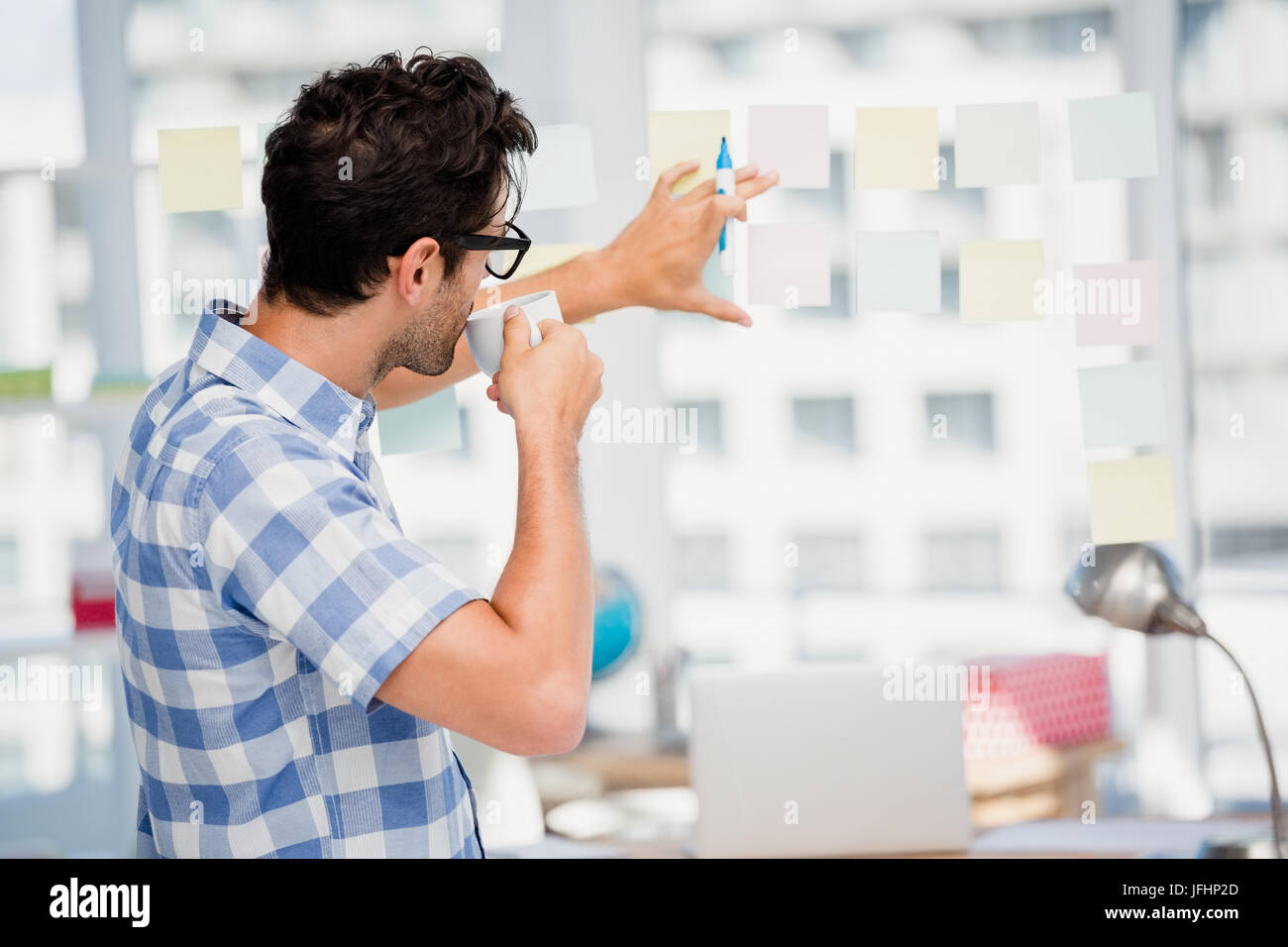 Man reading at sticky notes while having coffee Stock Photo - Alamy