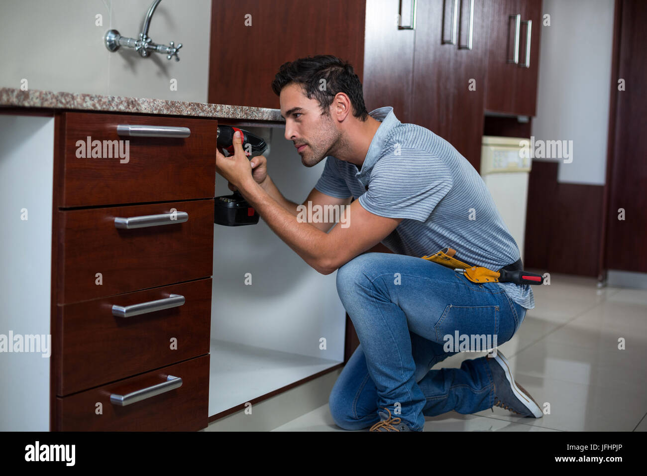 Full length of man using cordless hand drill Stock Photo - Alamy