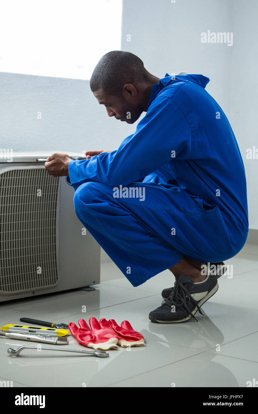Handyman testing air conditioner with screwdrive Stock Photo - Alamy