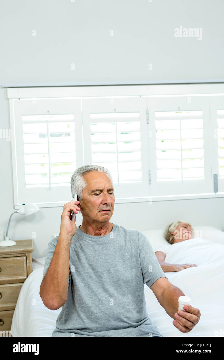 Old man talking on phone with woman sleeping Stock Photo - Alamy