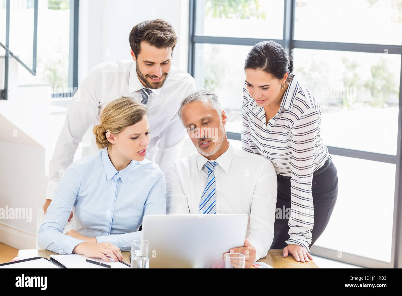 Business colleagues discussing office work on laptop Stock Photo - Alamy