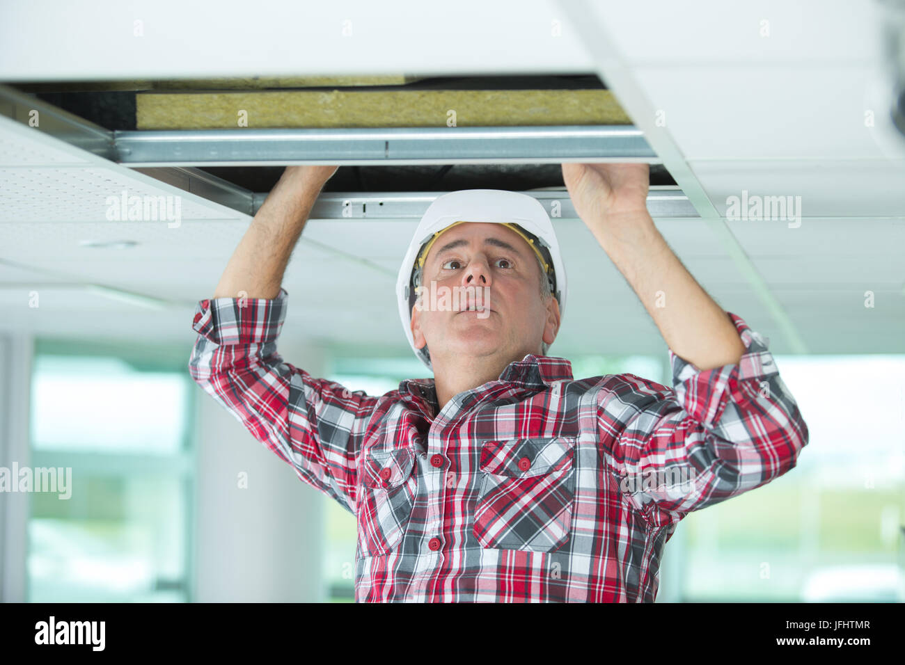 Contractor lifting ceiling panel Stock Photo - Alamy