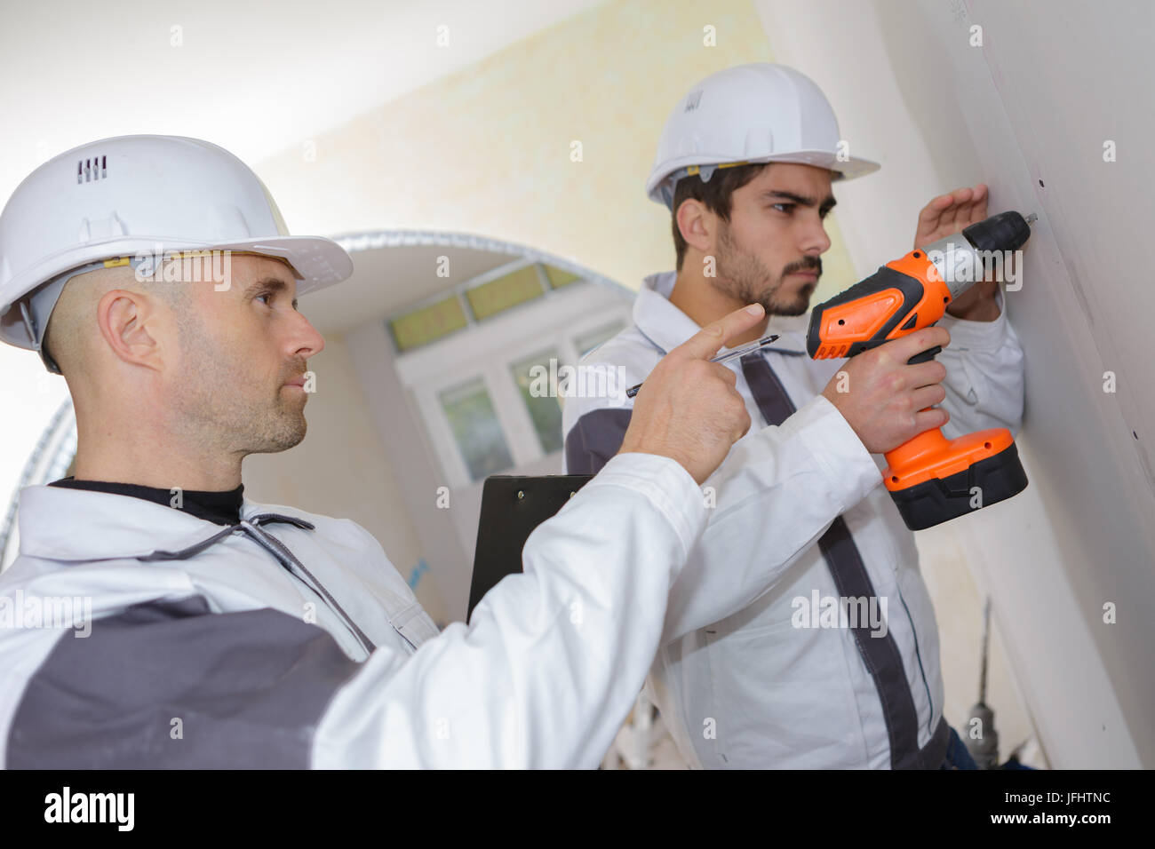 construction workers drilling a concrete wall Stock Photo - Alamy