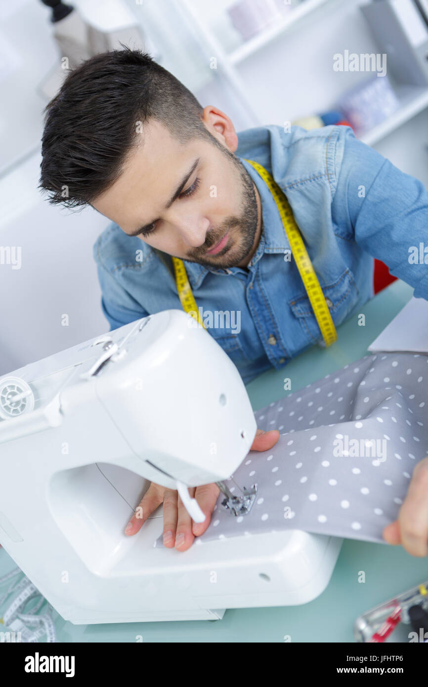 Young man sewing Stock Photo - Alamy