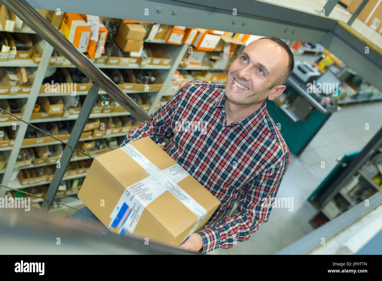 Man carrying parcel upstairs Stock Photo - Alamy