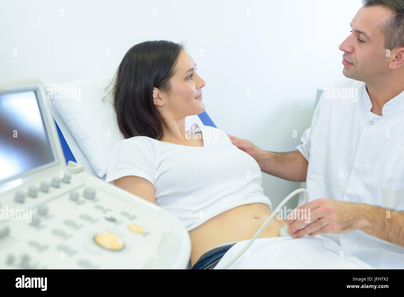 Doctor reassuring patient while performing ultrasound Stock Photo - Alamy