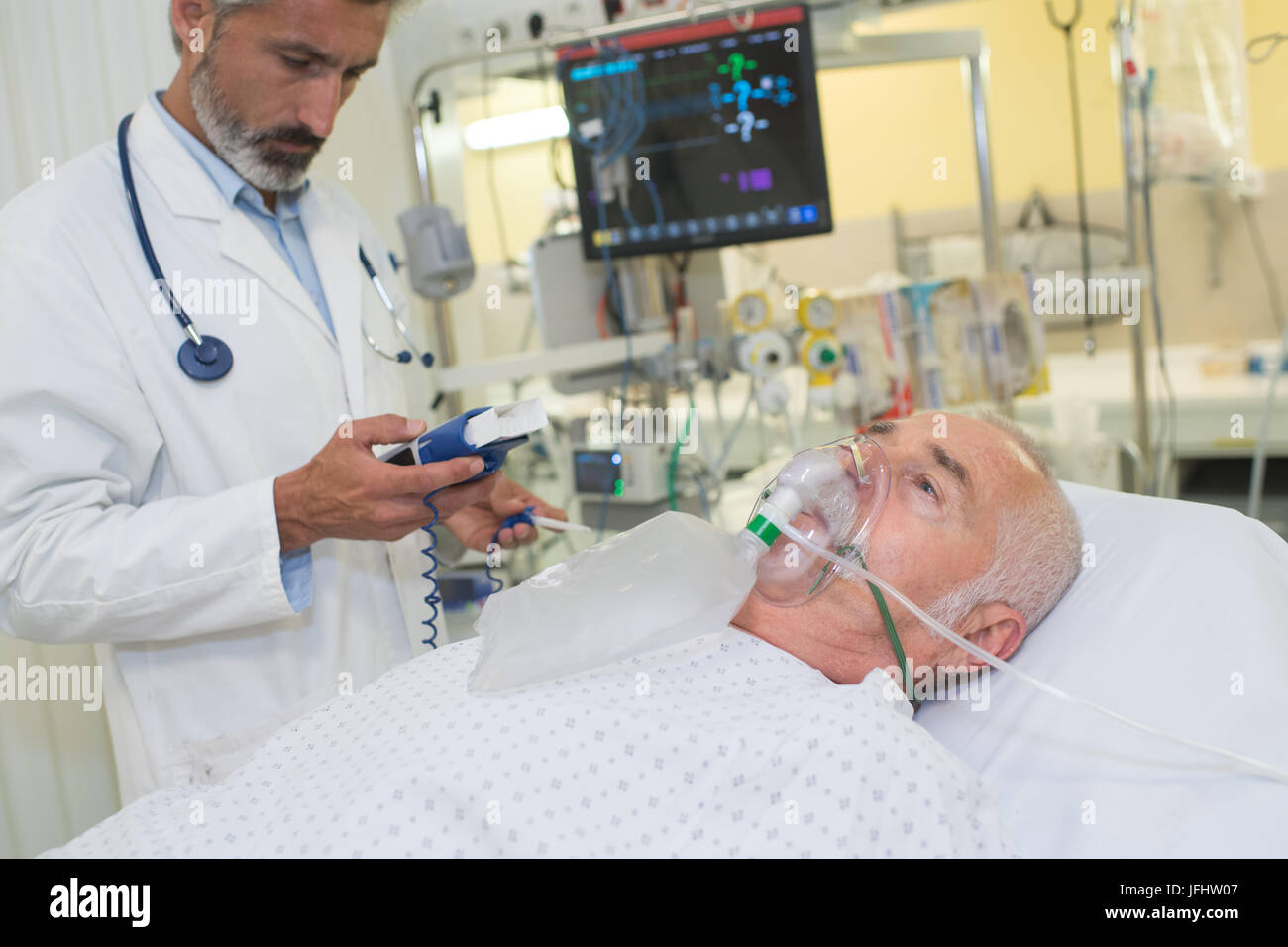 Doctor monitoring patient wearing oxygen mask Stock Photo - Alamy
