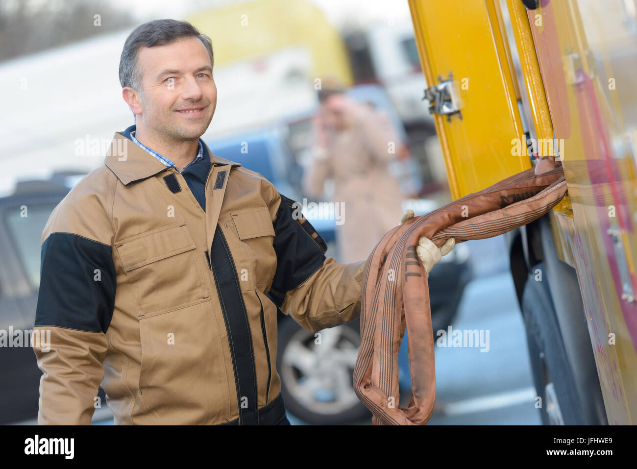 Man in uniform taking hose from vehicle Stock Photo - Alamy