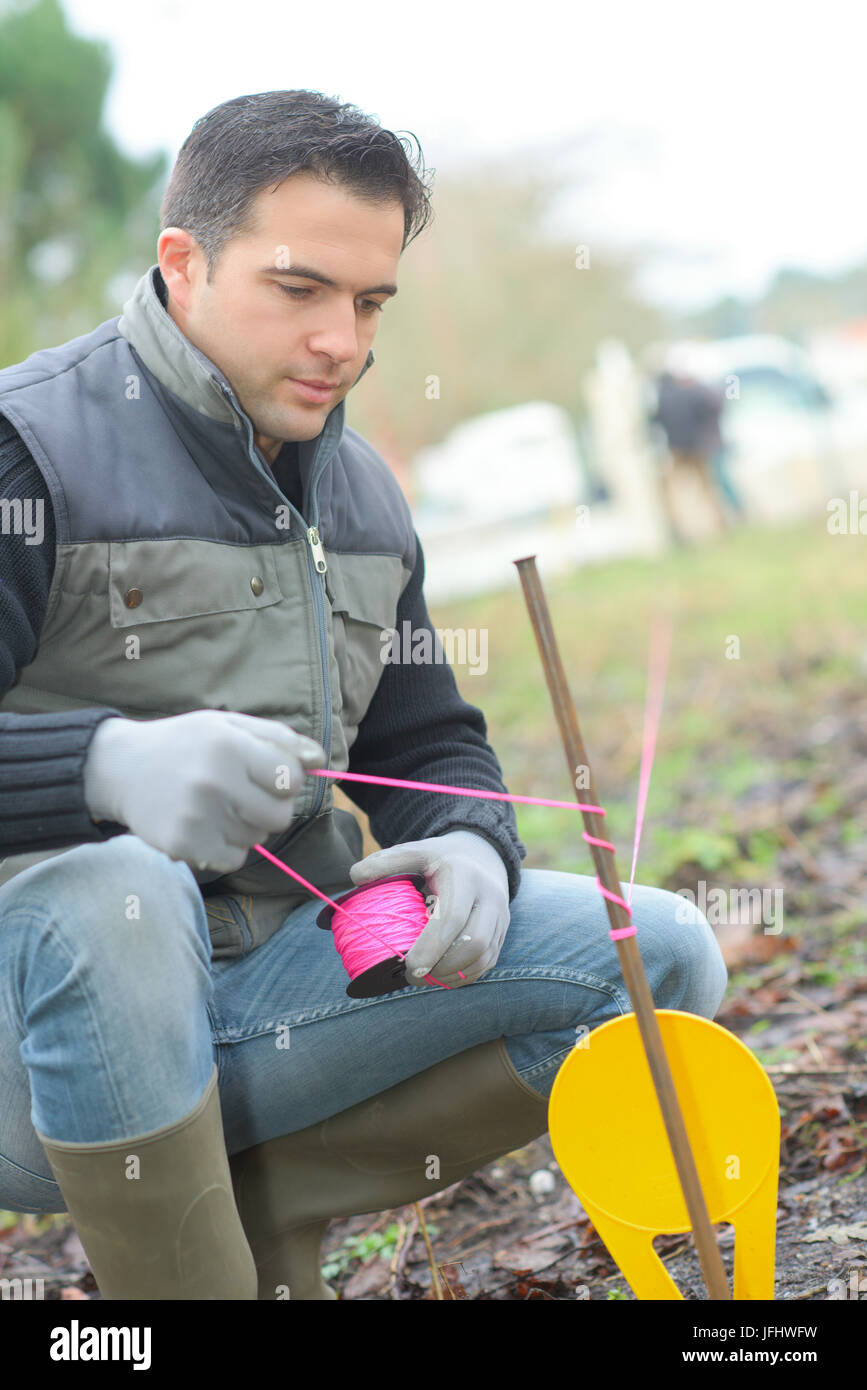 Man marking boundary with string Stock Photo - Alamy