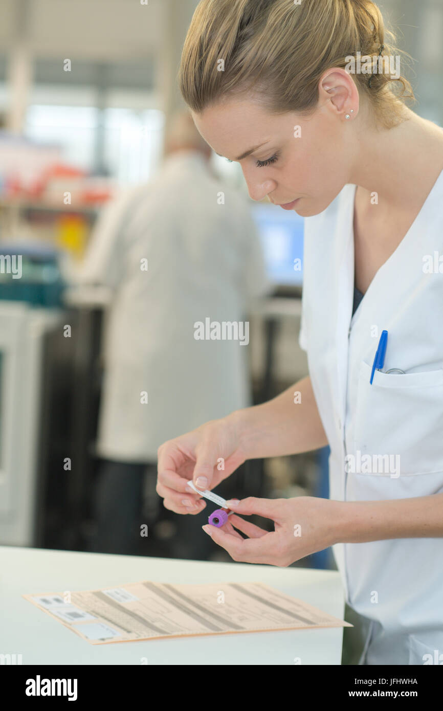 Laboratory worker sticking label onto blood sample Stock Photo - Alamy