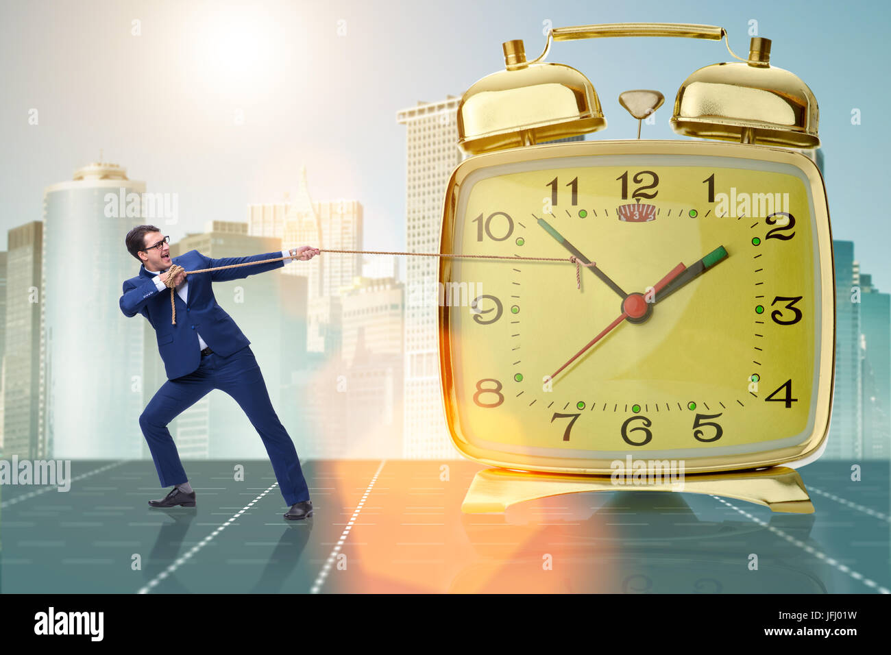 Businessman pulling clock in time management concept Stock Photo - Alamy