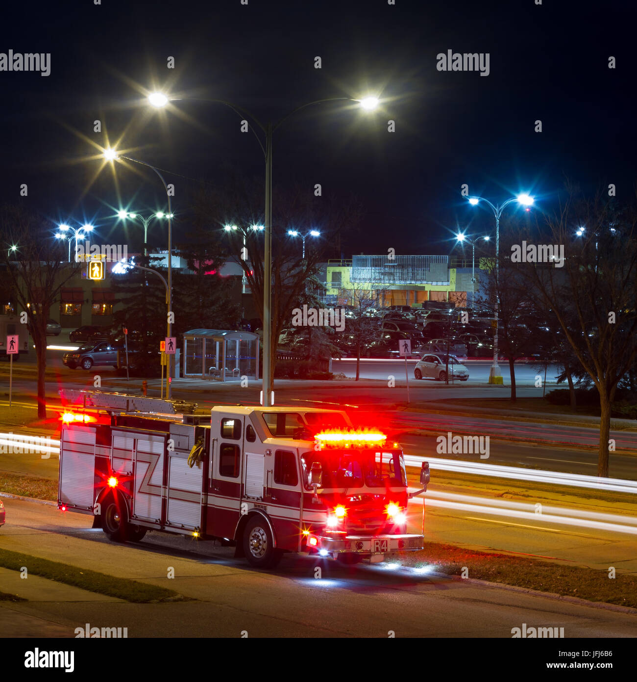 Firetruck is on the side of the road at night in the city Stock Photo ...