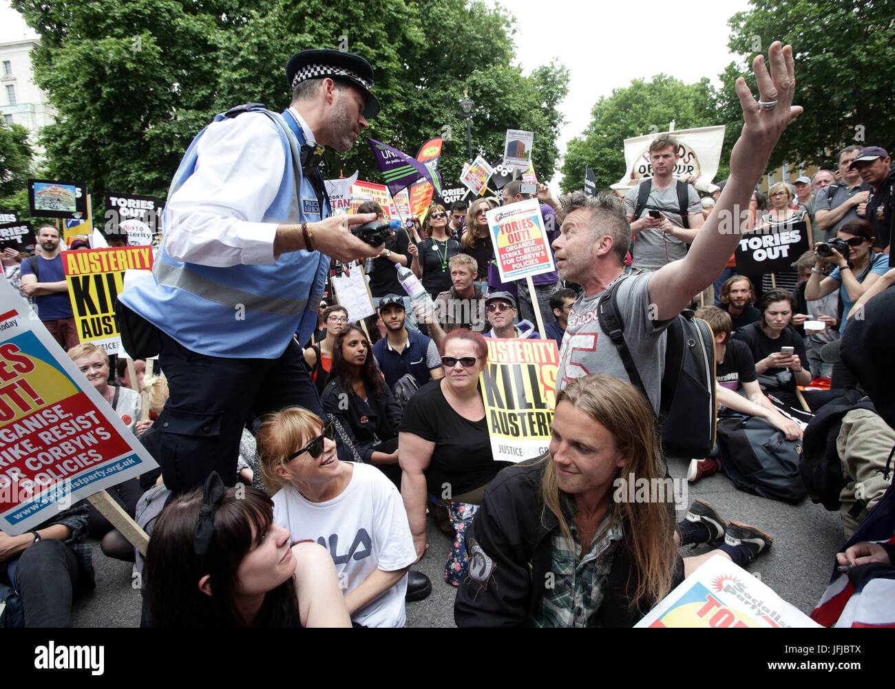 A police liaison officer speaks with a group of people taking part in a ...