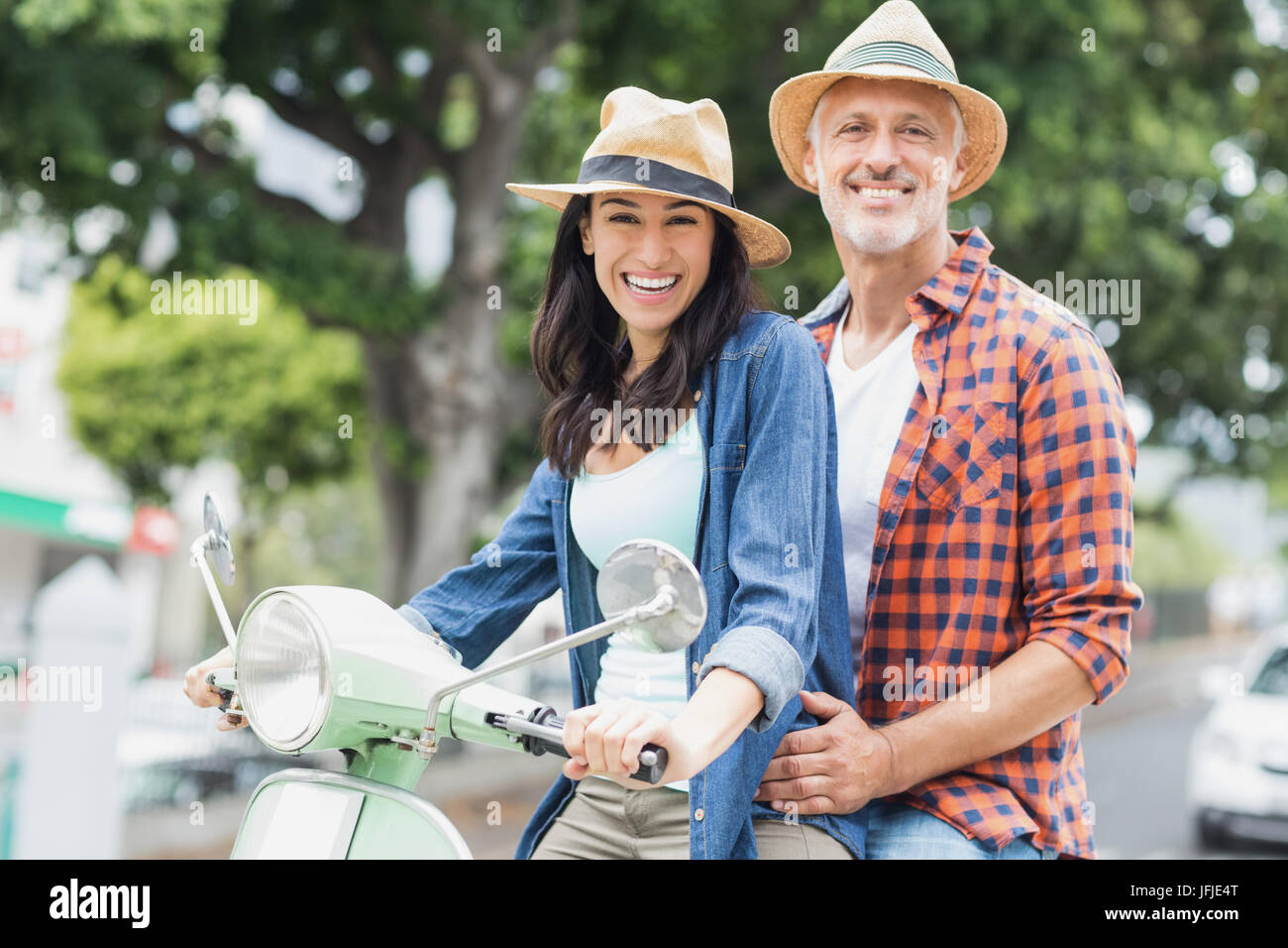 Portrait of happy couple on moped Stock Photo - Alamy