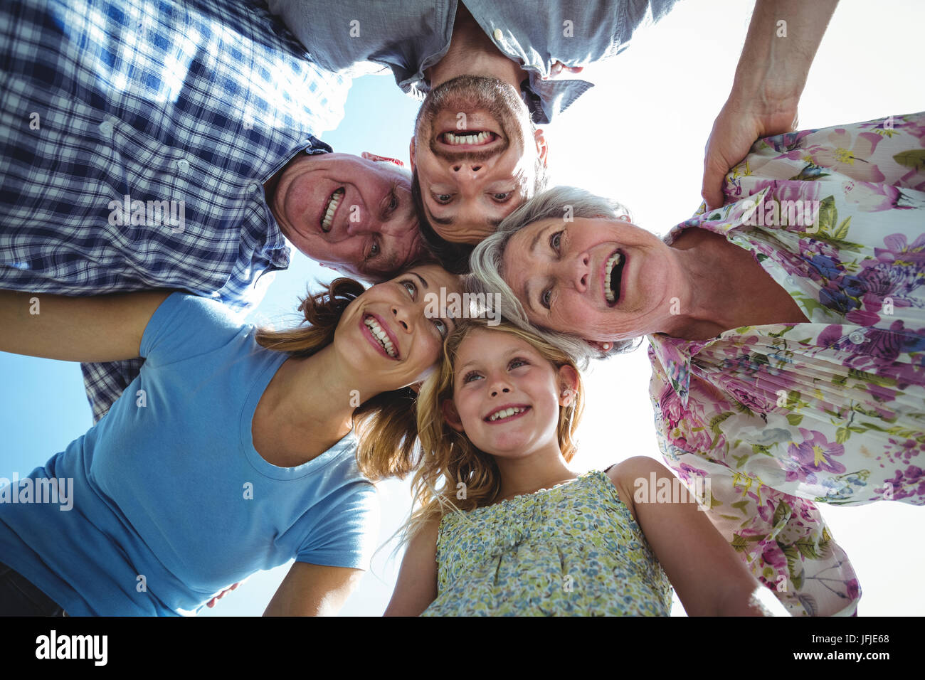 Laughing family forming huddle against sky Stock Photo - Alamy