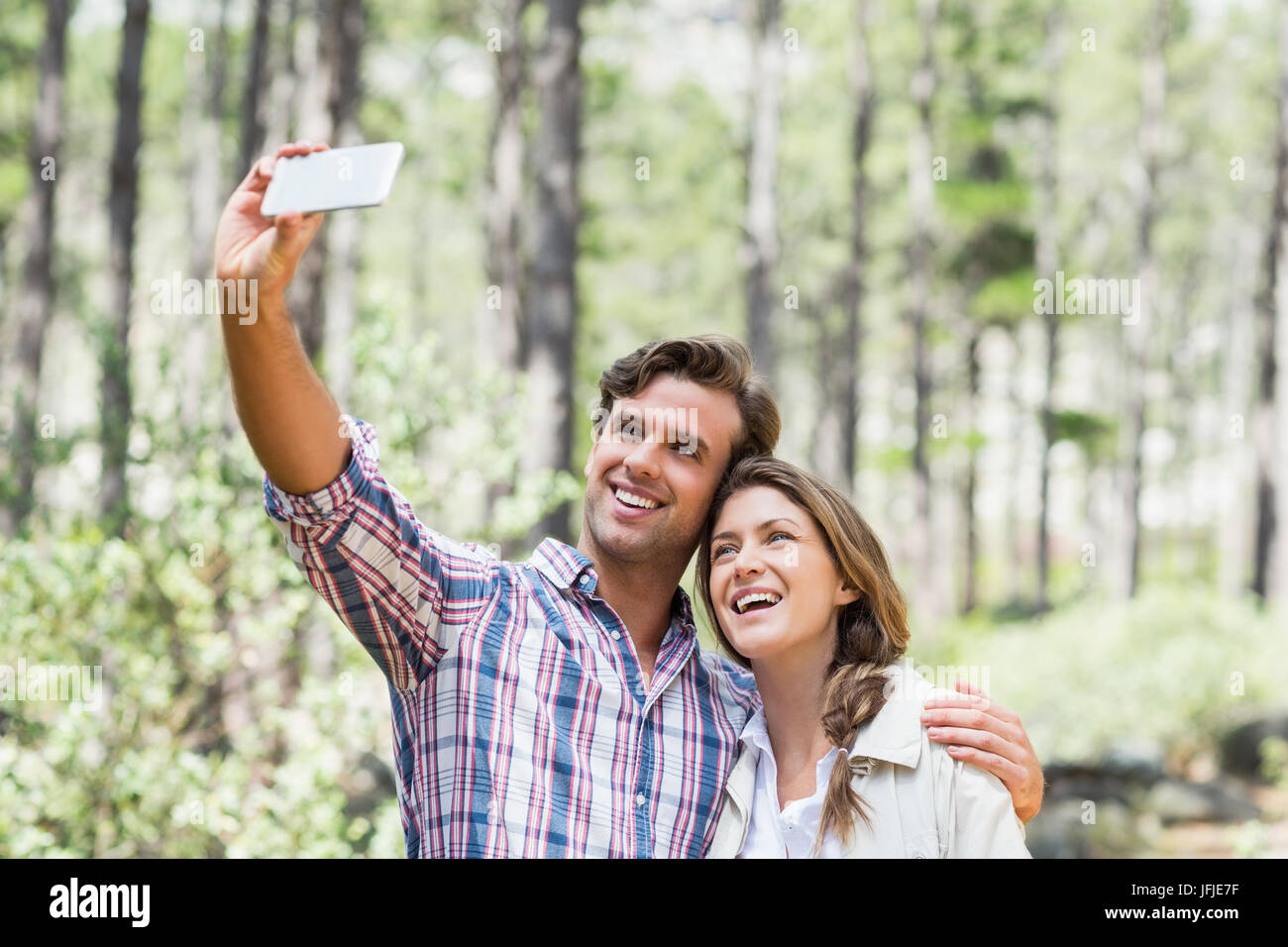 Smiling couple clicking selfie with smart phone Stock Photo - Alamy