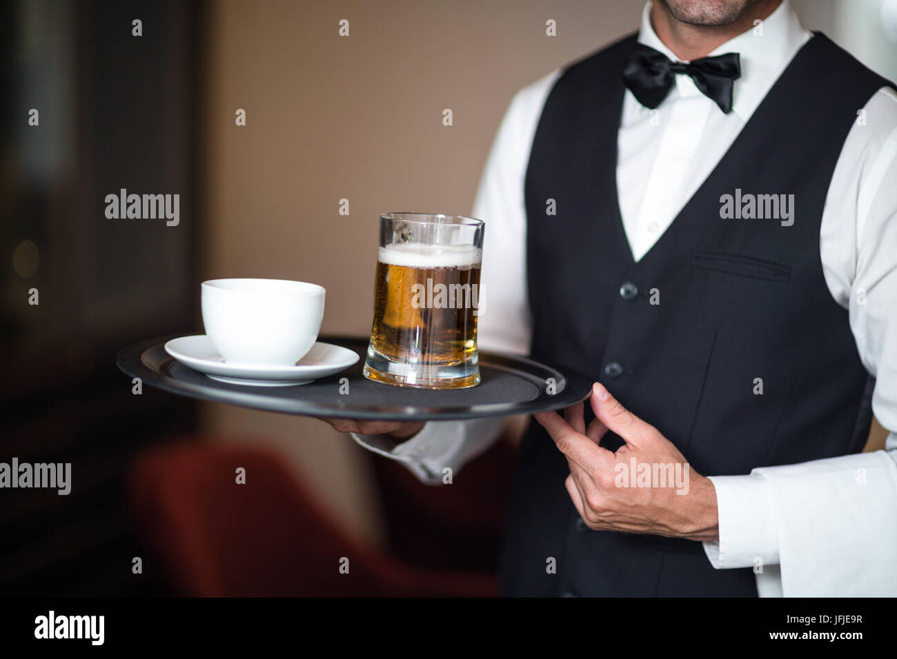 Waiter holding tray with beer Stock Photo - Alamy