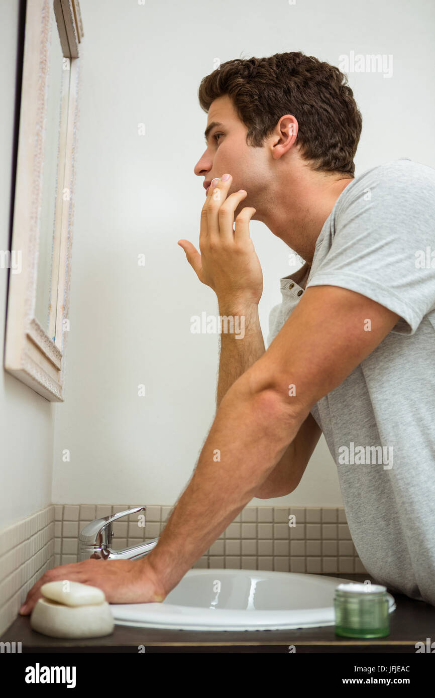 Man applying moisturizer on his face Stock Photo - Alamy