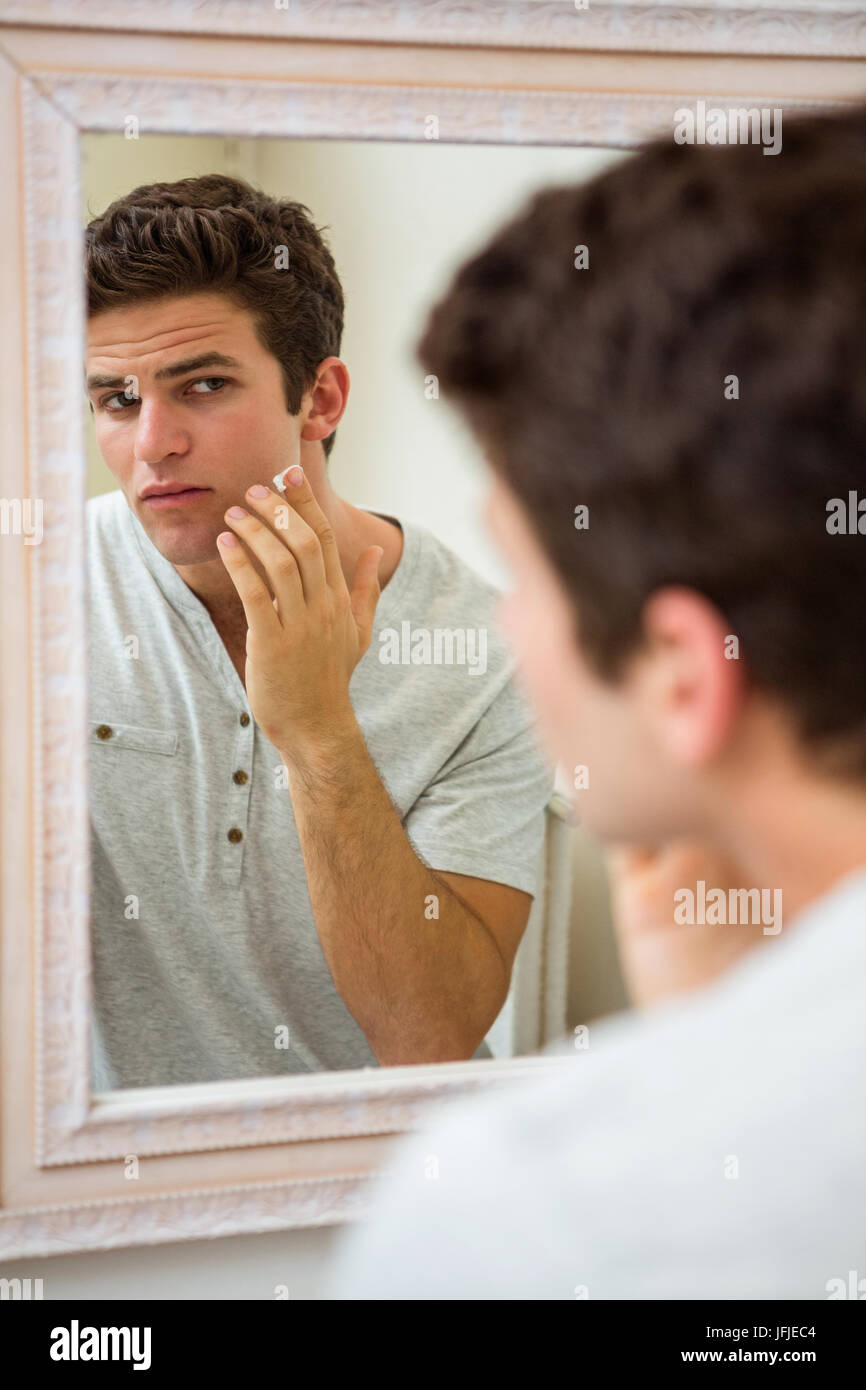Man applying moisturizer on his face Stock Photo - Alamy