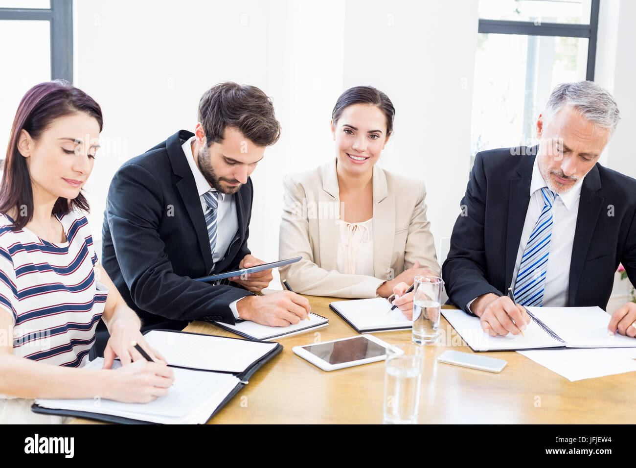 Workers are reading their notes and one is smiling Stock Photo - Alamy