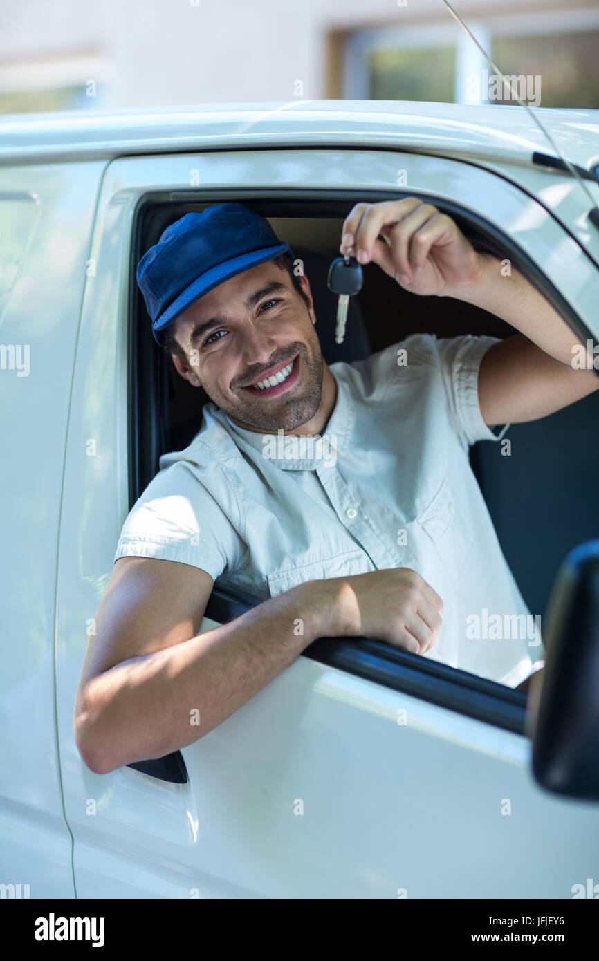 Portrait of smiling delivery man showing car keys Stock Photo - Alamy