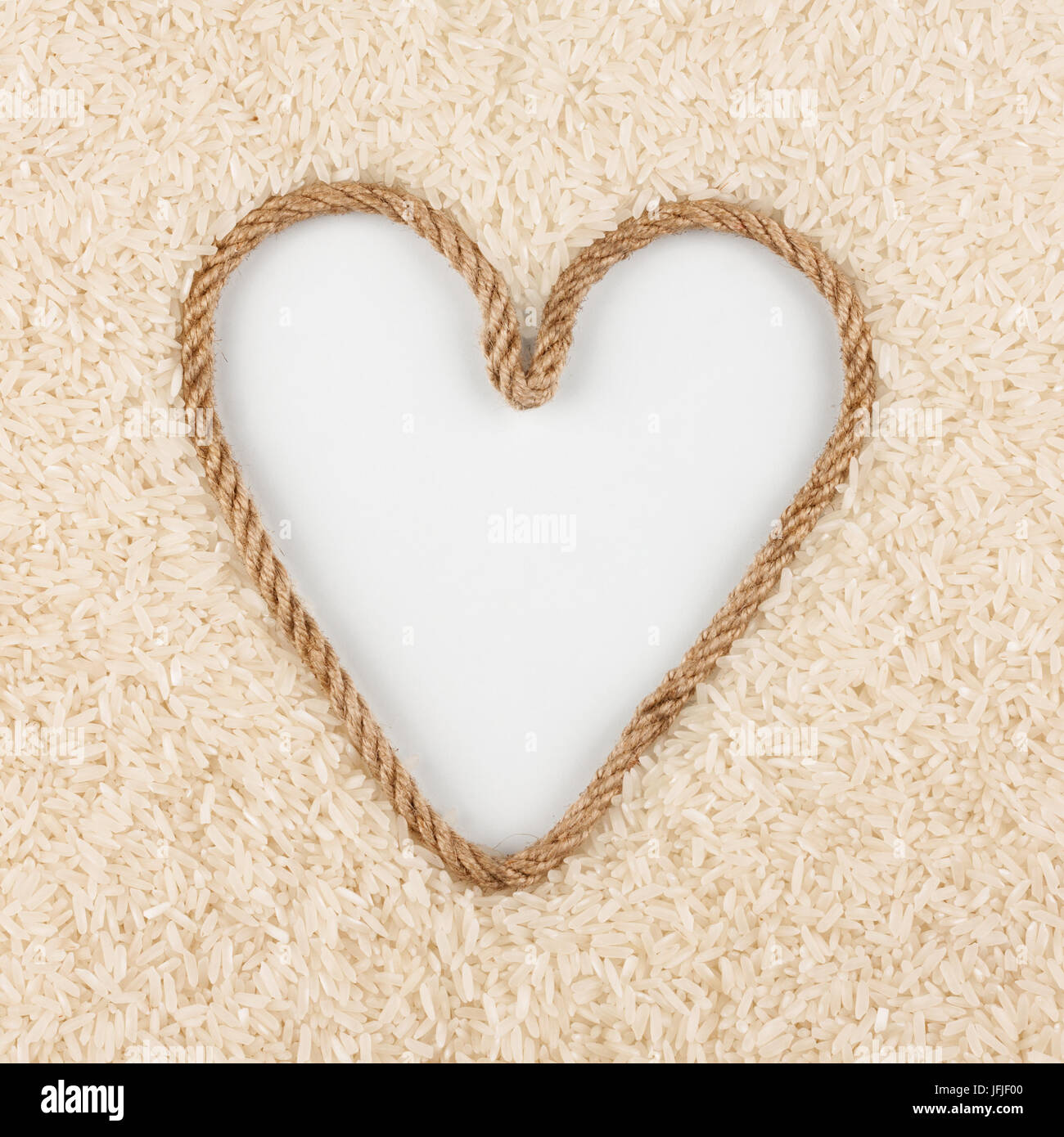Rice grains and a rope in the shape of a heart with a place for ...