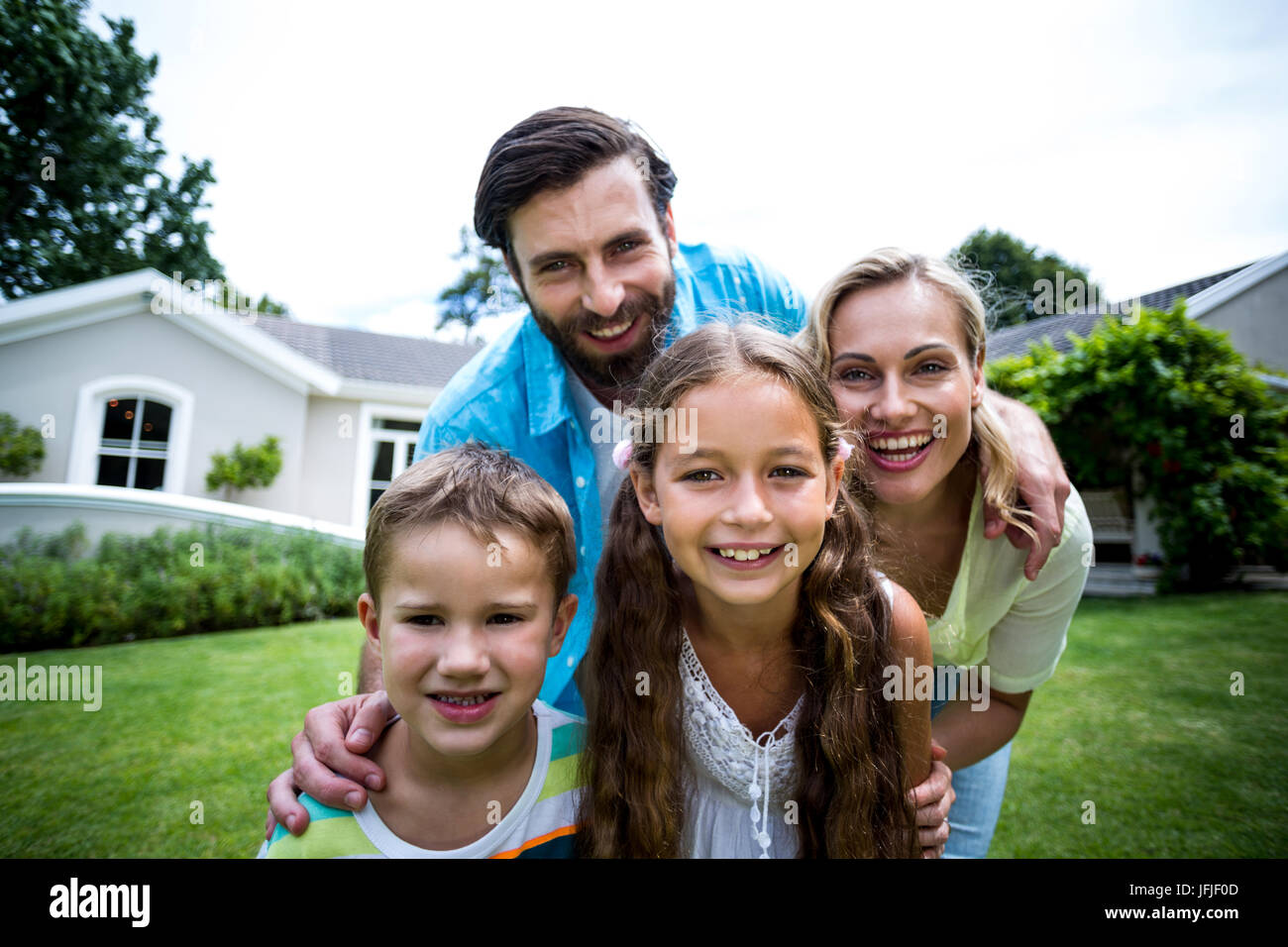 Portrait of family standing outside house in yard Stock Photo - Alamy