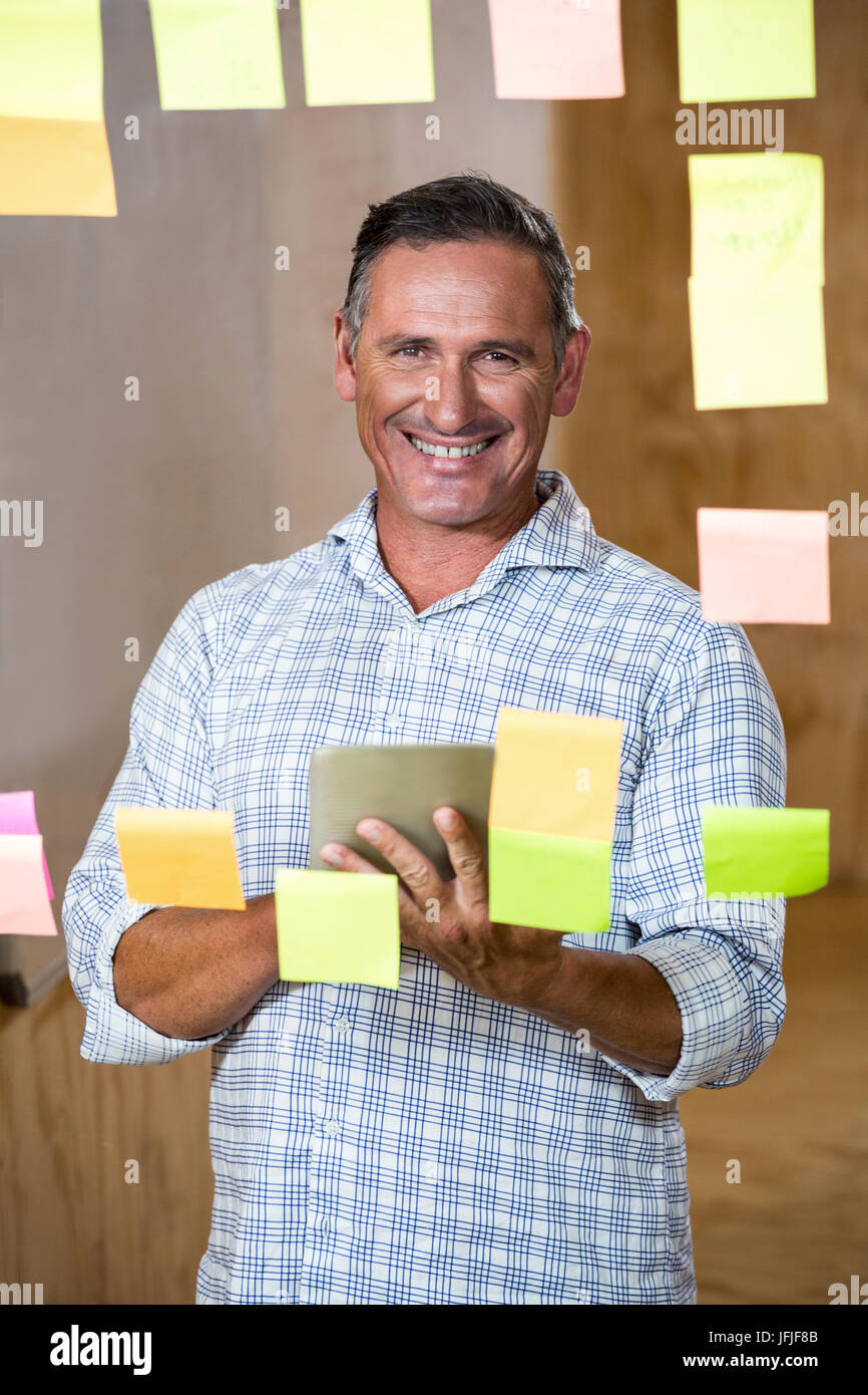 Man holding digital tablet and sticky notes on window Stock Photo - Alamy