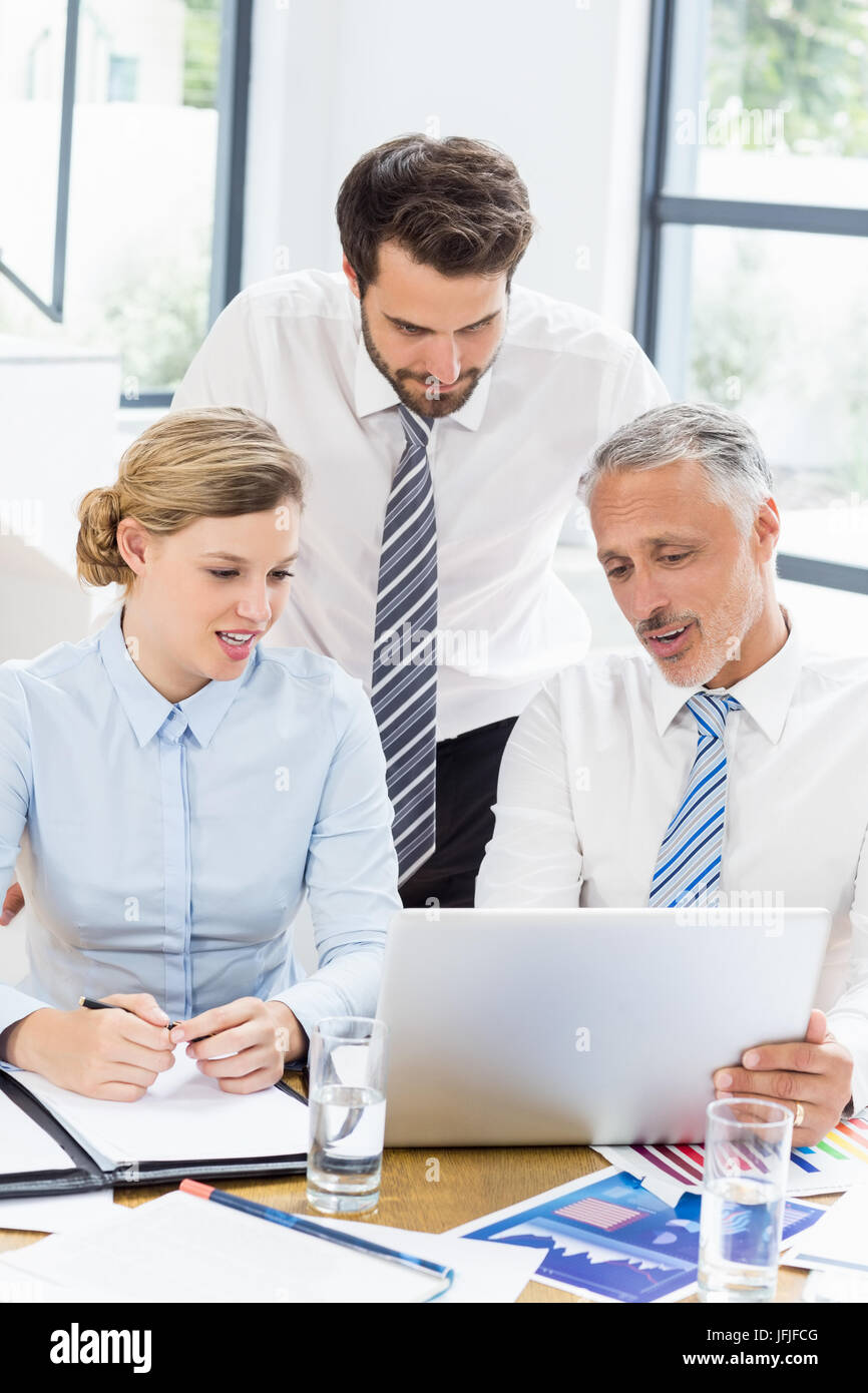 Business colleagues discussing office work on laptop Stock Photo - Alamy