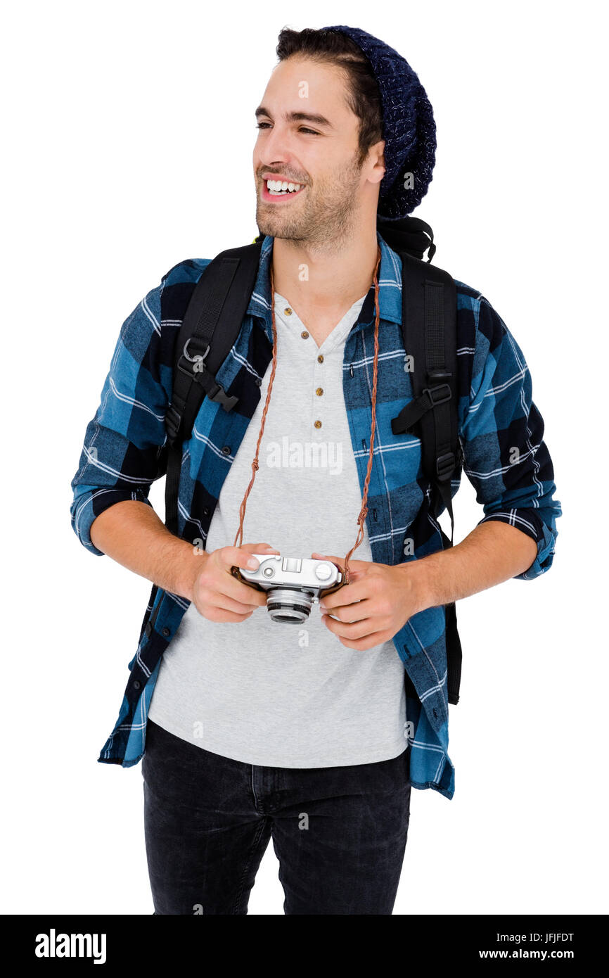 Young man carrying rucksack and holding camera Stock Photo - Alamy