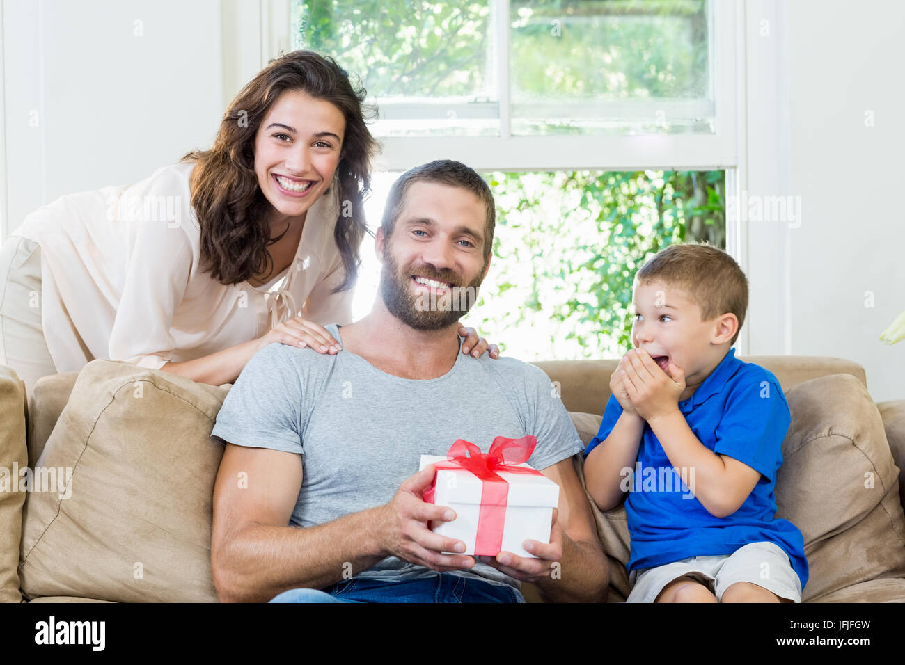 Father receiving a gift from his son and wife Stock Photo - Alamy