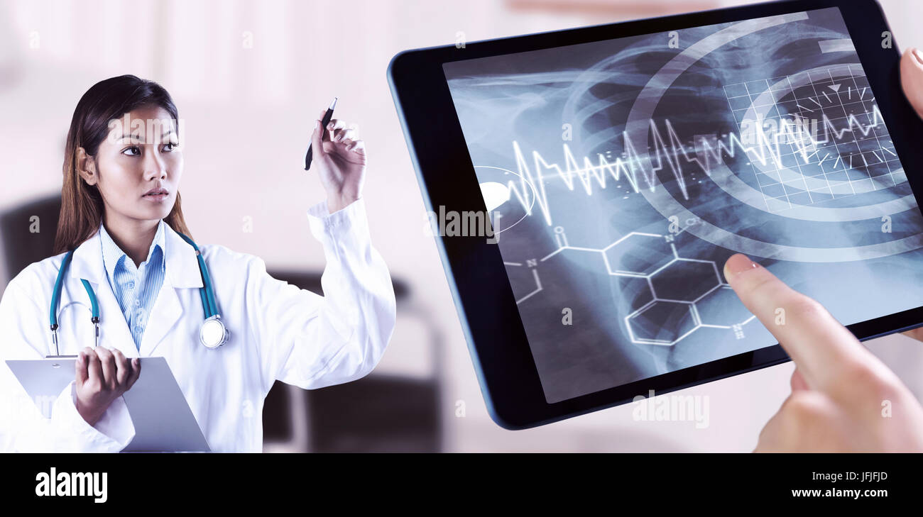 Composite image of asian doctor pointing with pen Stock Photo - Alamy